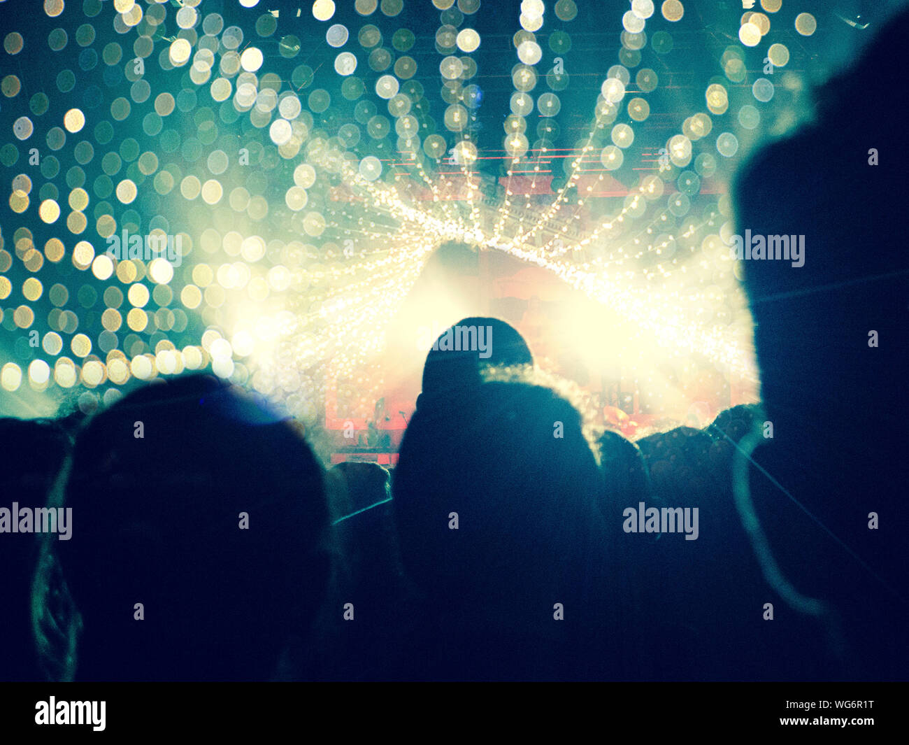Concert crowd clapping in front of a bright stage Stock Photo - Alamy