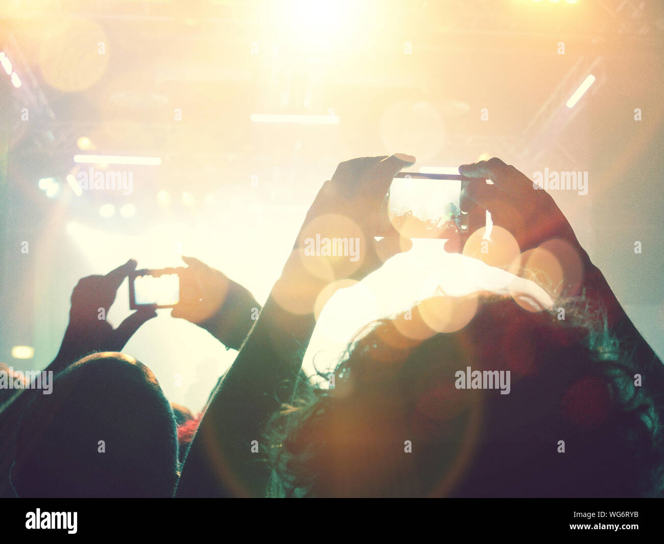 Concert crowd clapping in front of a bright stage Stock Photo - Alamy