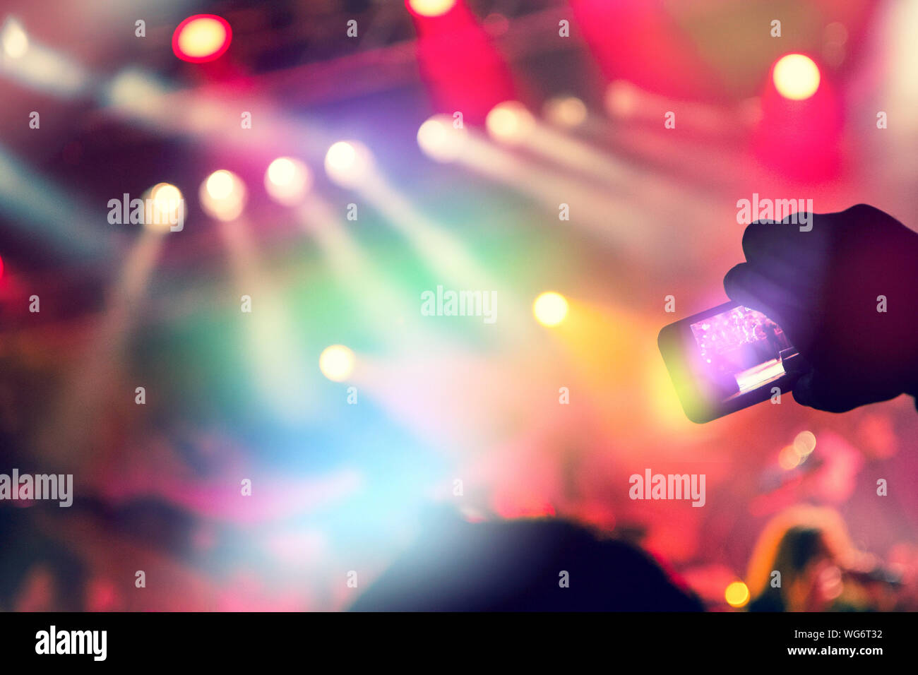 Concert crowd clapping in front of a bright stage Stock Photo - Alamy