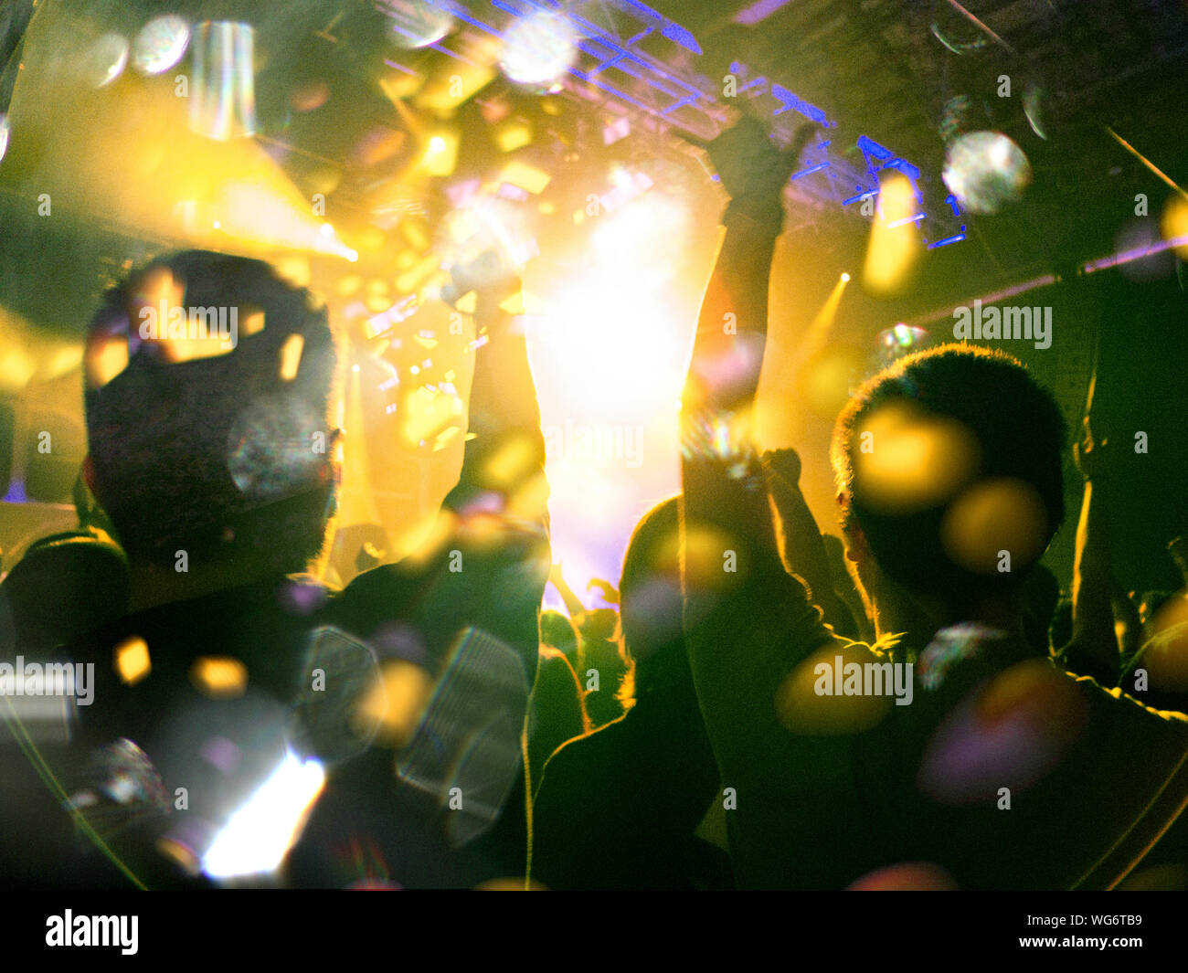 Concert crowd clapping in front of a bright stage Stock Photo - Alamy
