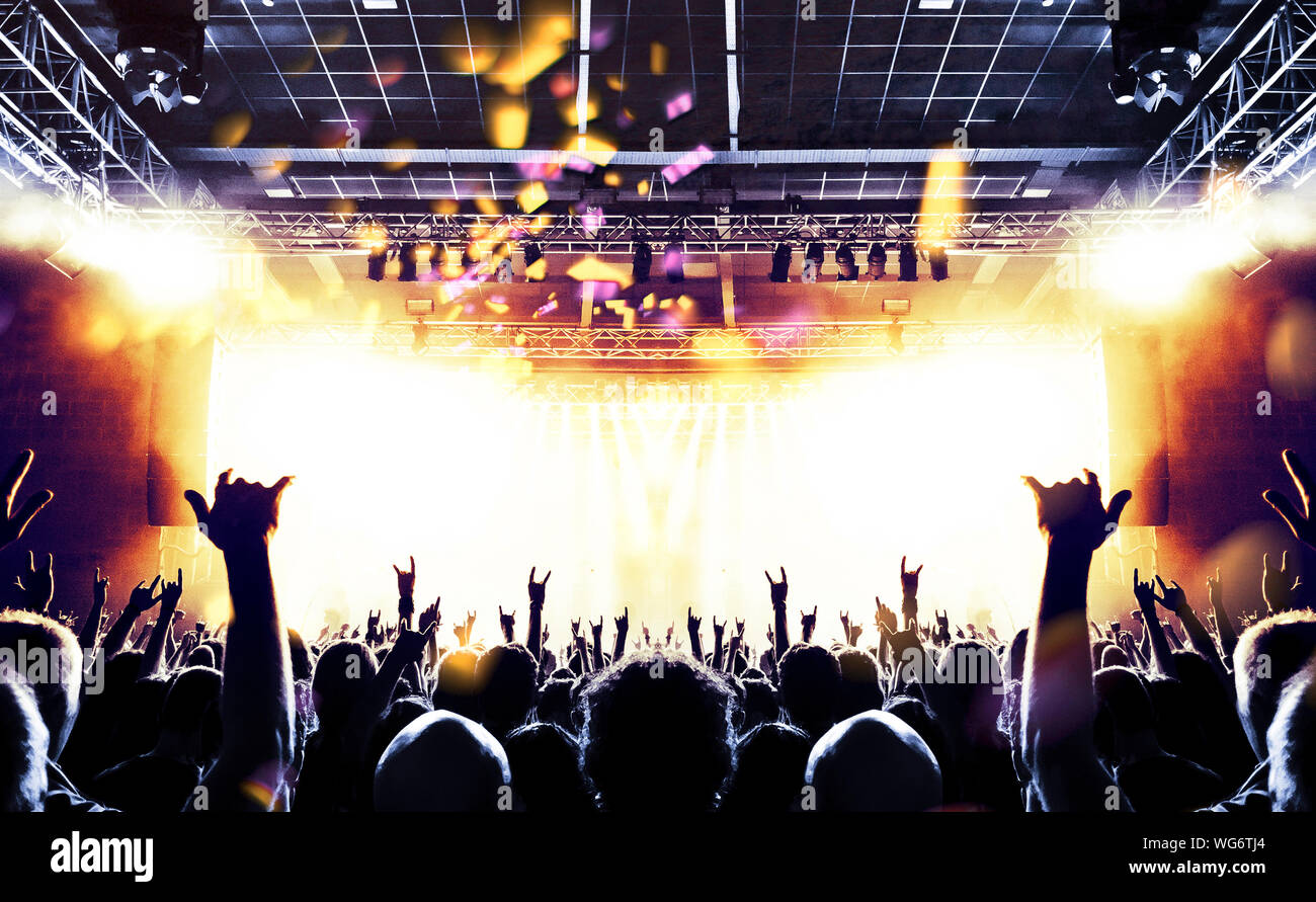 Concert crowd clapping in front of a bright stage Stock Photo - Alamy