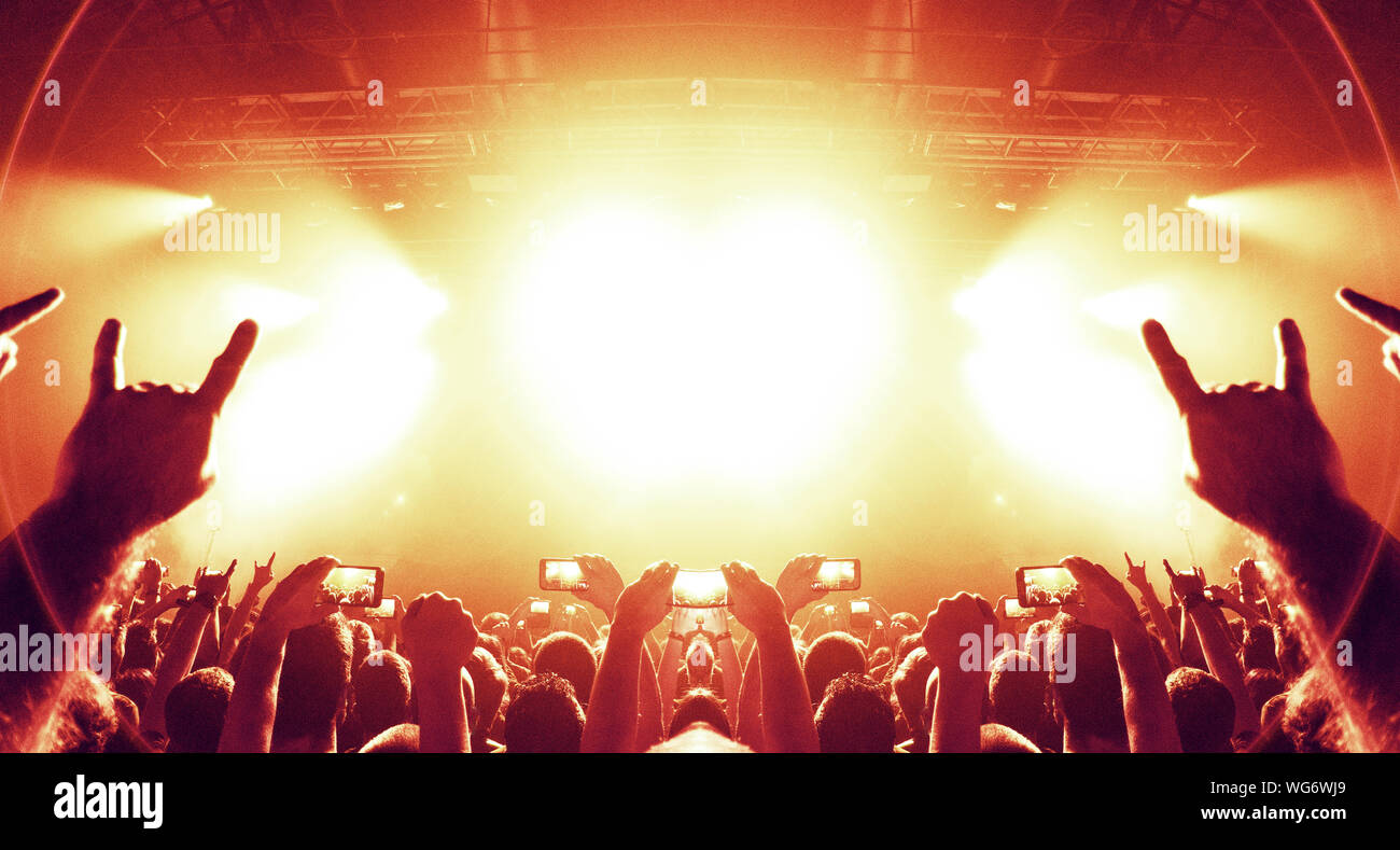 Concert crowd clapping in front of a bright stage Stock Photo - Alamy