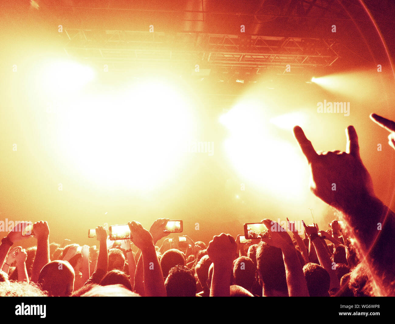 Concert crowd clapping in front of a bright stage Stock Photo - Alamy