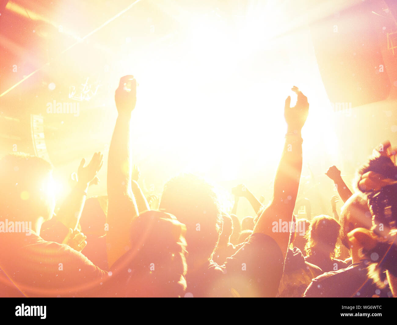 Concert crowd clapping in front of a bright stage Stock Photo - Alamy