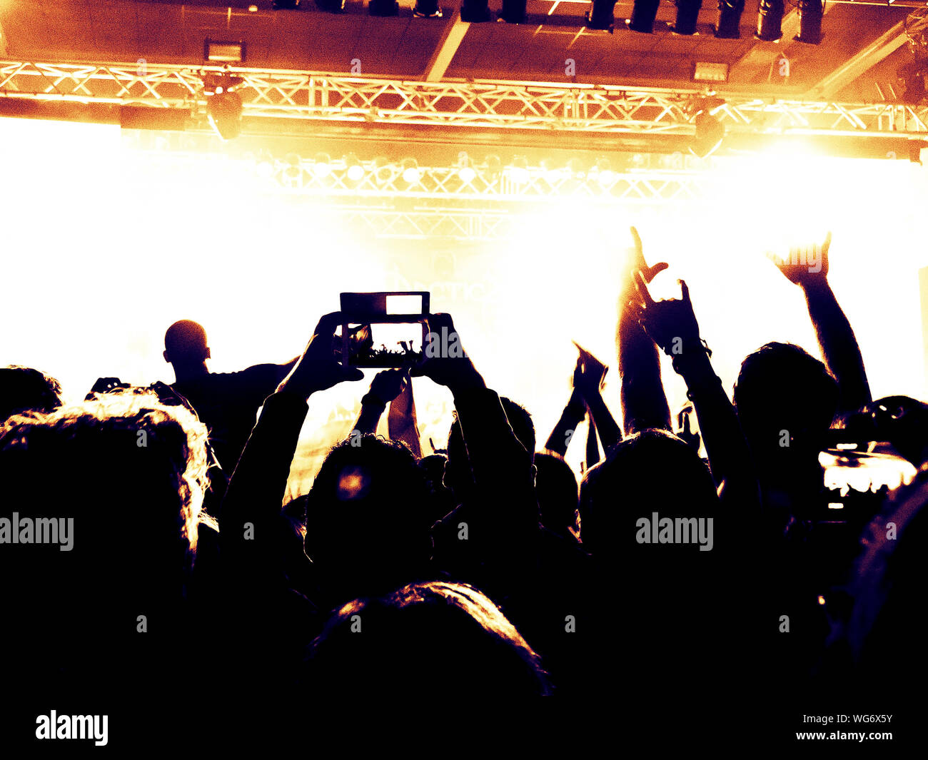 Concert crowd clapping in front of a bright stage Stock Photo - Alamy
