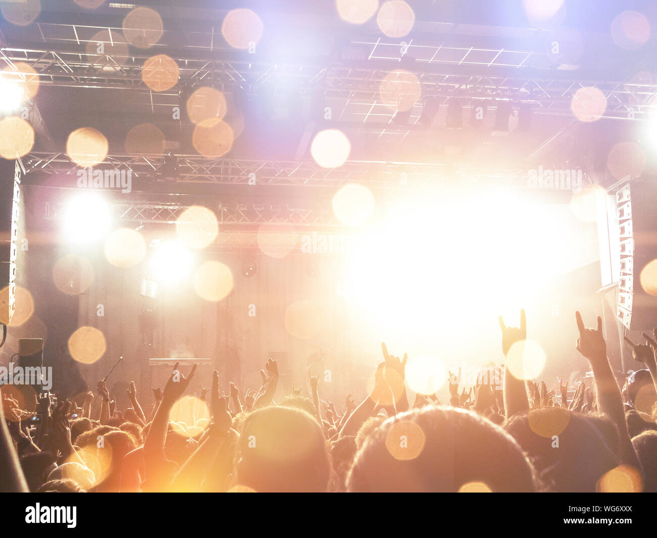 Concert crowd clapping in front of a bright stage Stock Photo - Alamy