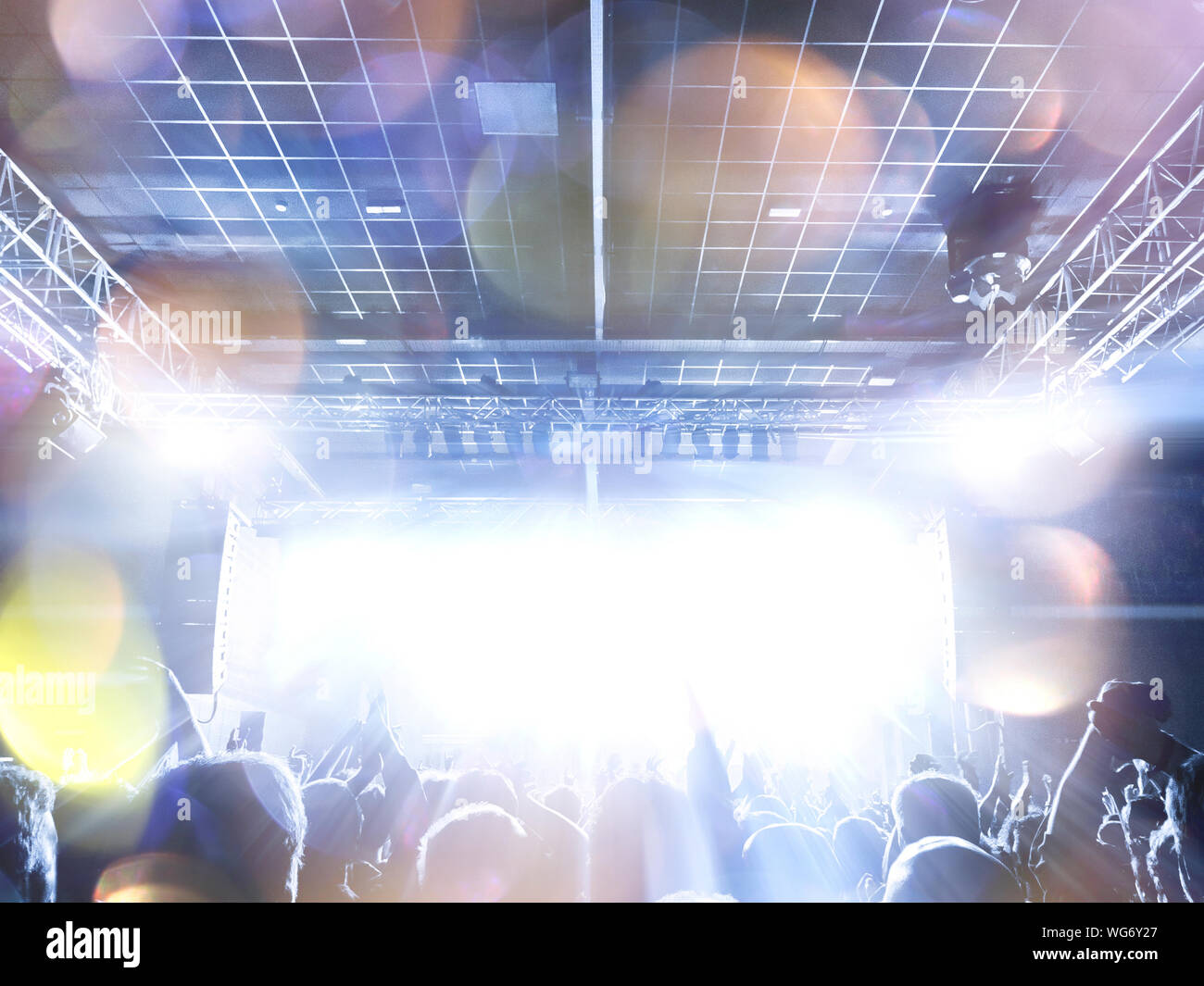 Concert crowd clapping in front of a bright stage Stock Photo - Alamy