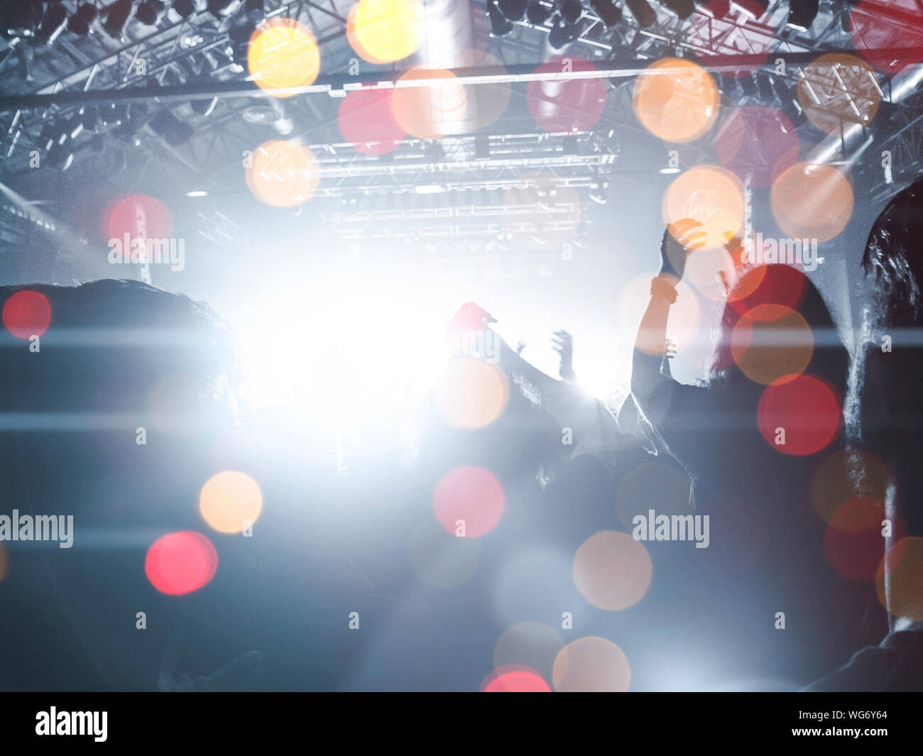 Concert crowd clapping in front of a bright stage Stock Photo - Alamy