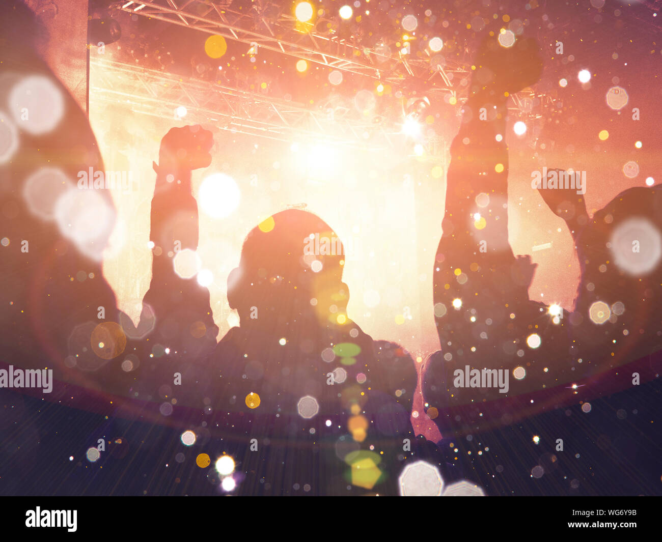 Concert crowd clapping in front of a bright stage Stock Photo - Alamy