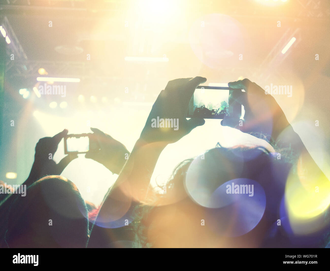 Concert crowd clapping in front of a bright stage Stock Photo - Alamy