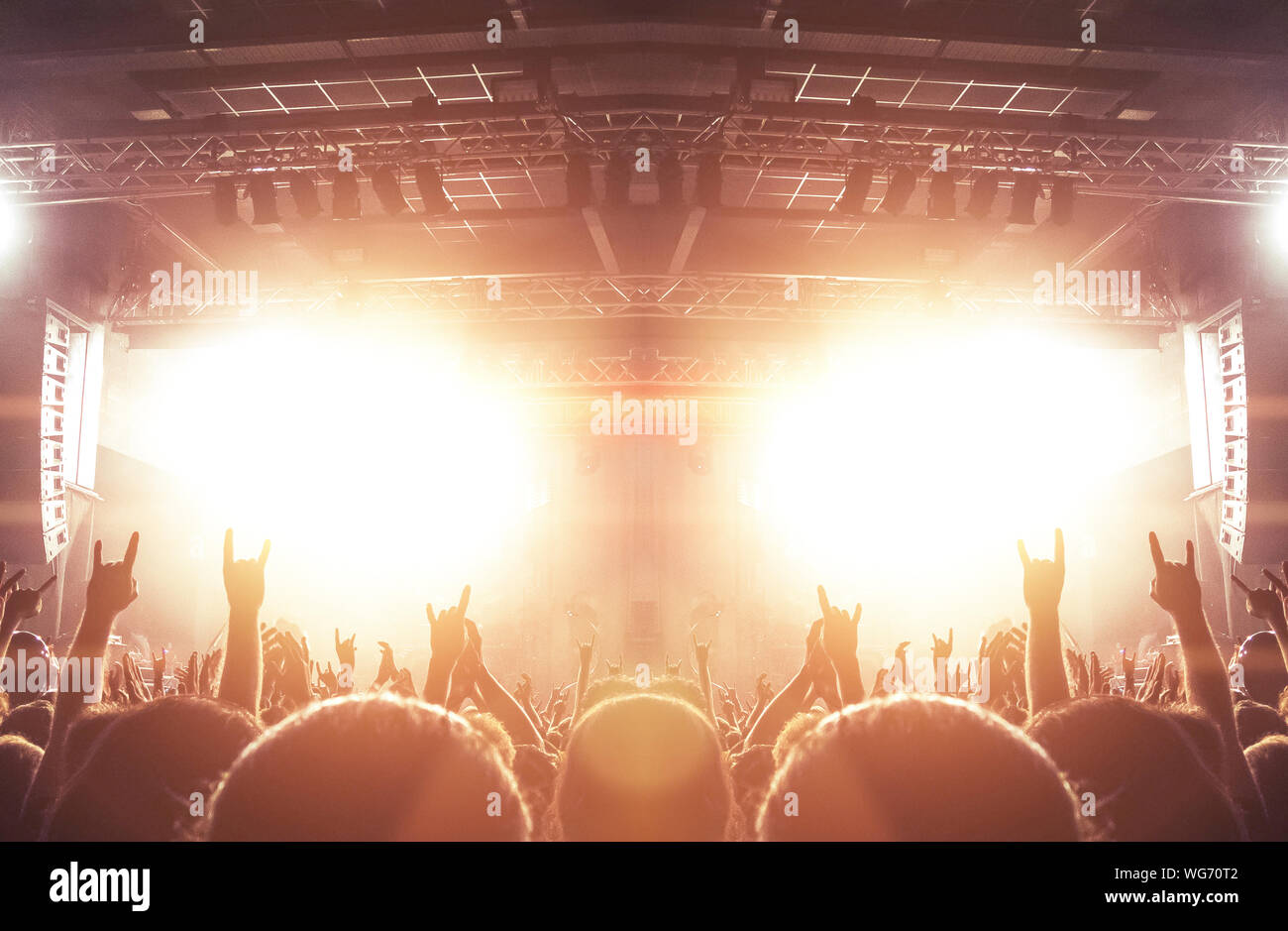 Concert crowd clapping in front of a bright stage Stock Photo - Alamy