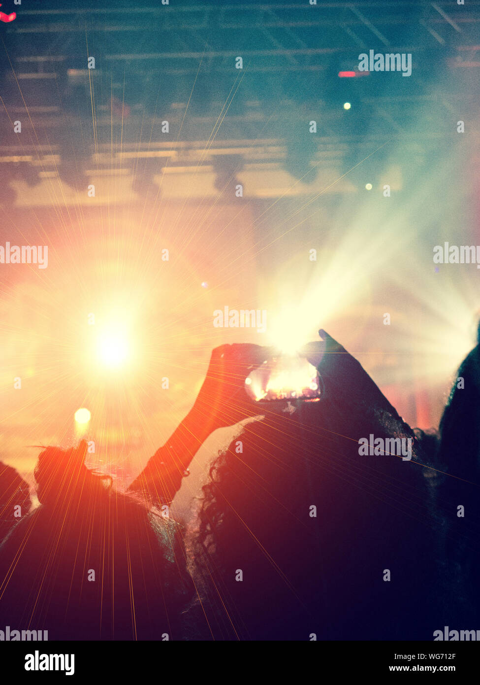 Concert crowd clapping in front of a bright stage Stock Photo - Alamy