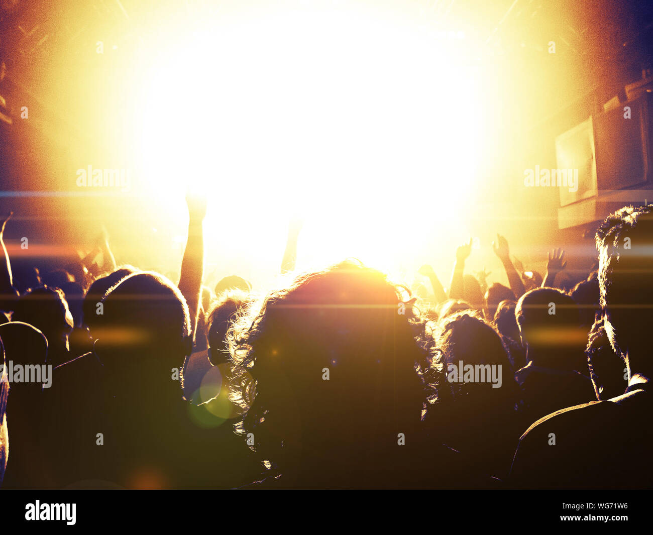 Concert crowd clapping in front of a bright stage Stock Photo - Alamy