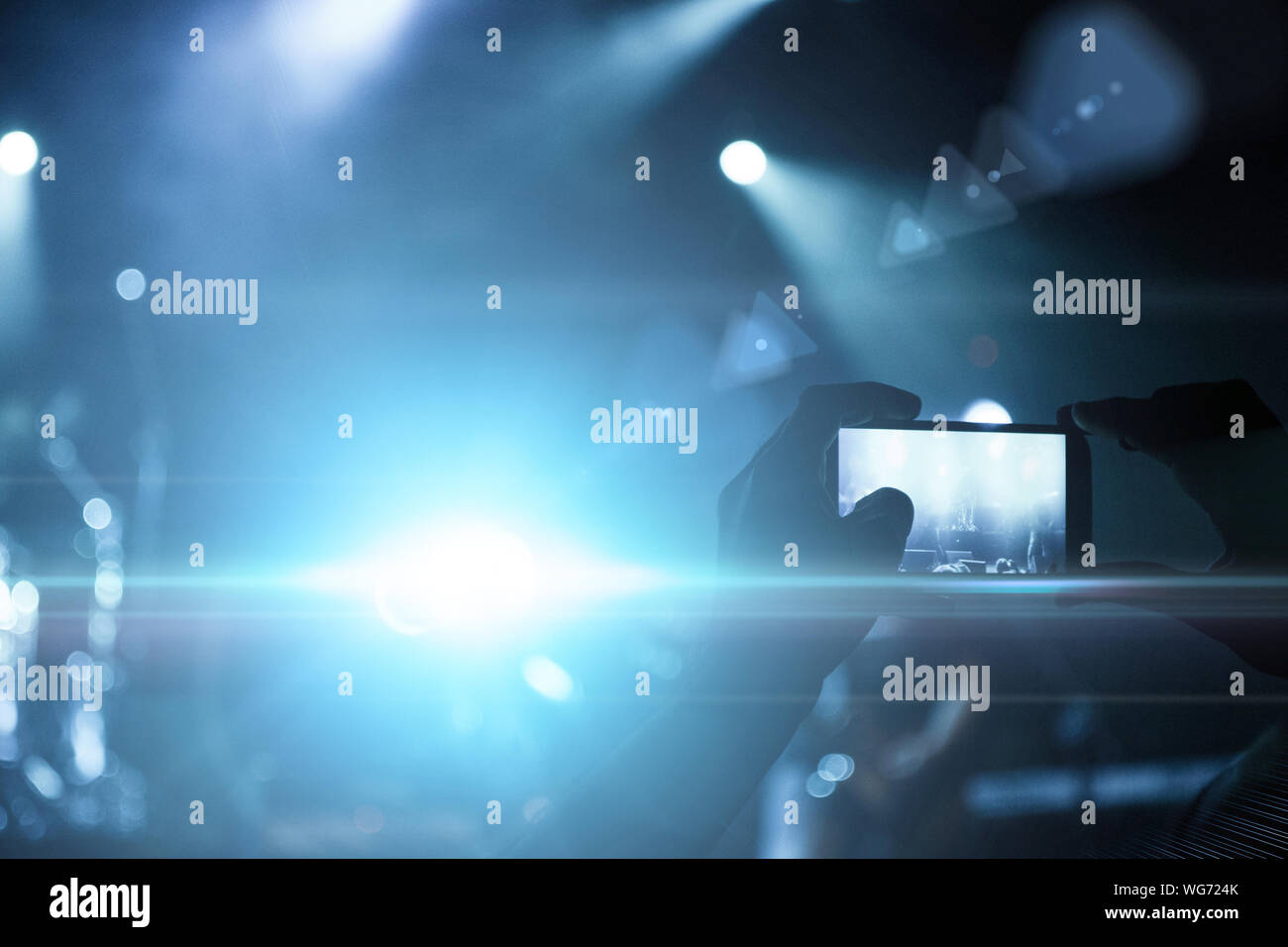 Concert crowd clapping in front of a bright stage Stock Photo - Alamy
