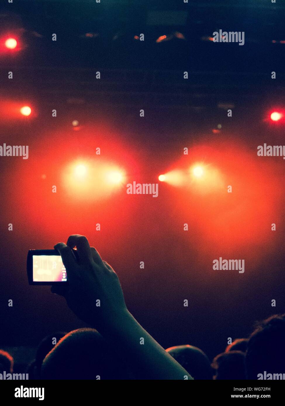 Concert crowd clapping in front of a bright stage Stock Photo - Alamy