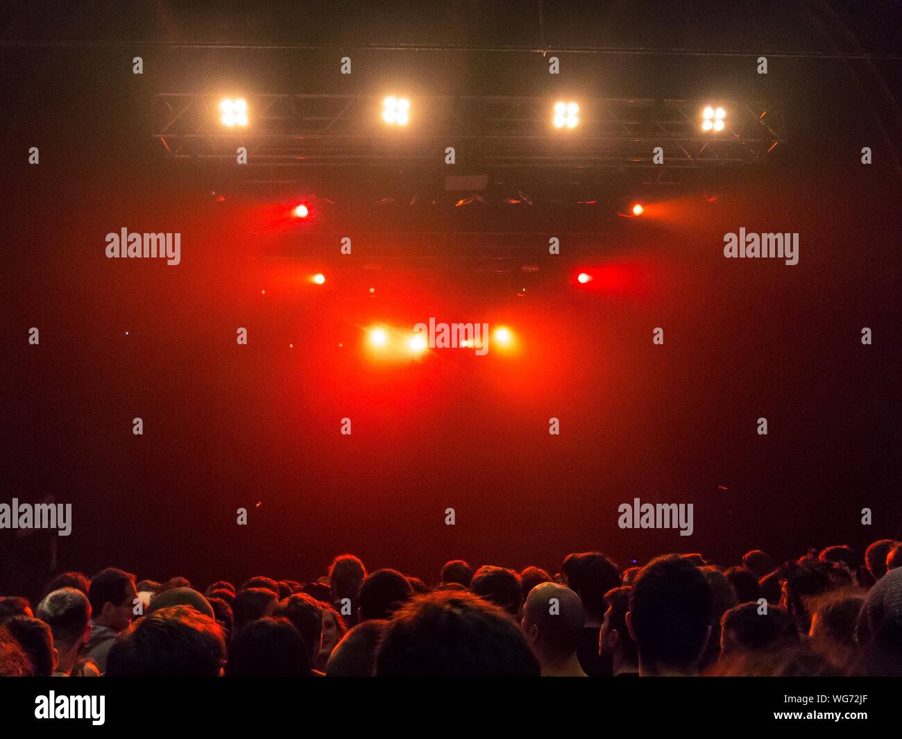 Concert crowd clapping in front of a bright stage Stock Photo - Alamy