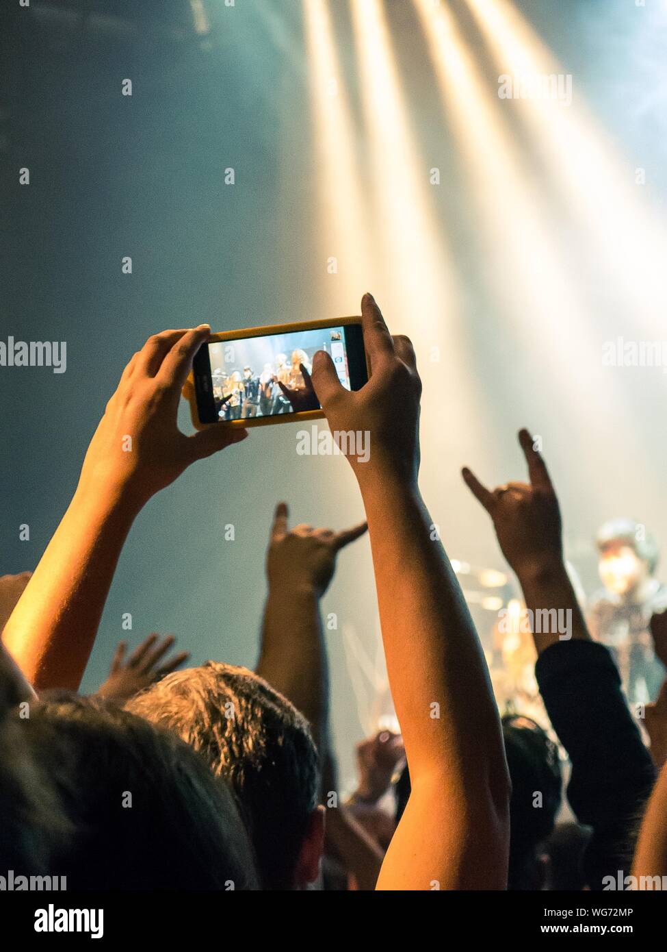 Concert crowd clapping in front of a bright stage Stock Photo - Alamy