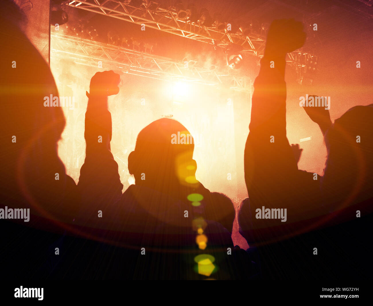 Concert crowd clapping in front of a bright stage Stock Photo - Alamy
