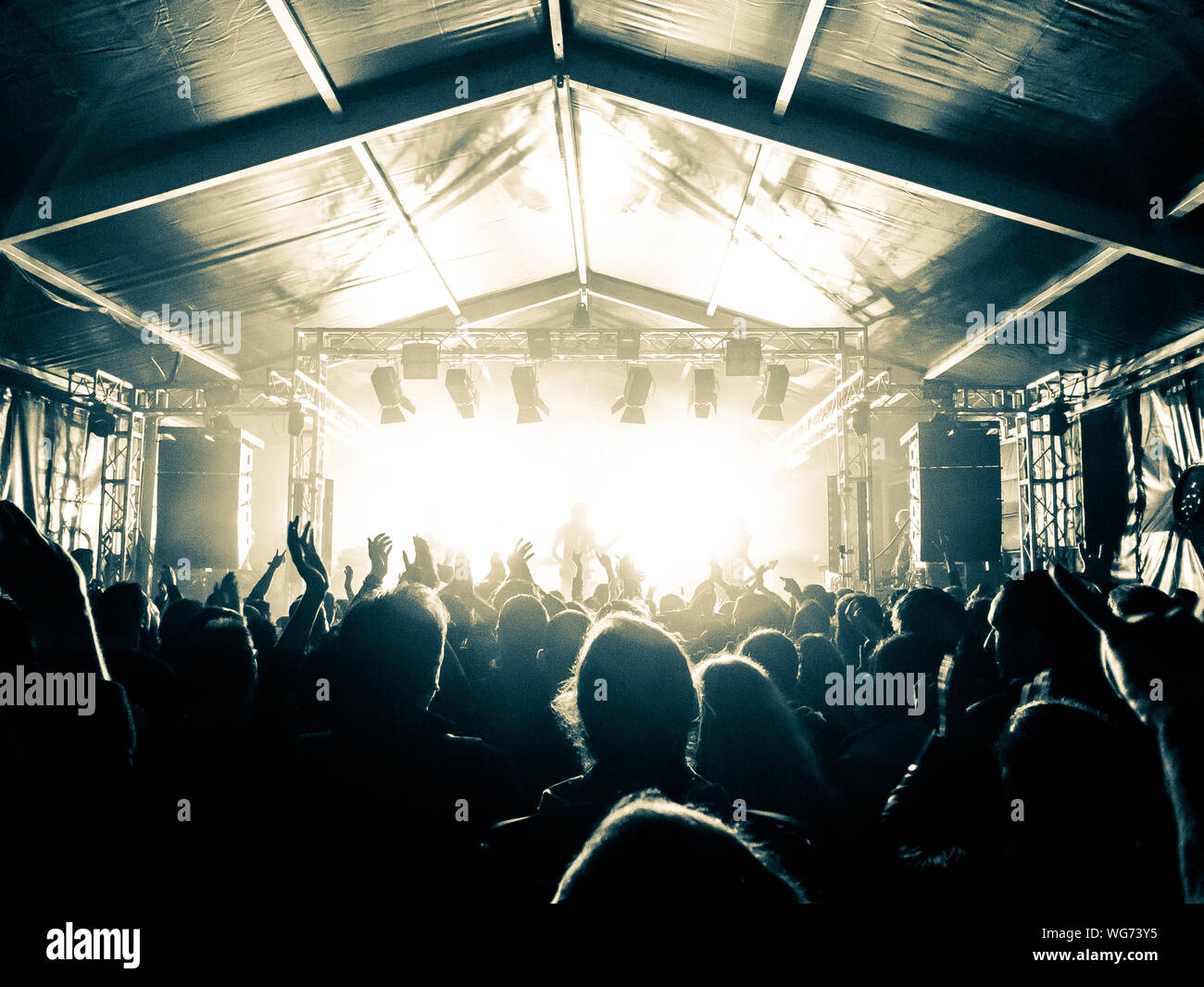 Concert crowd clapping in front of a bright stage Stock Photo - Alamy
