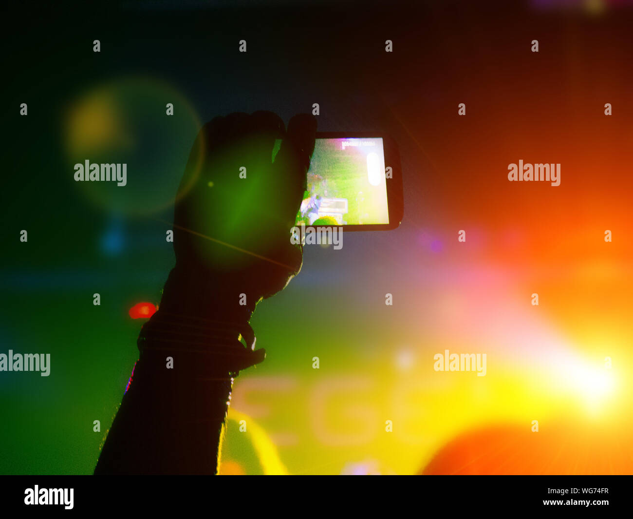 Concert crowd clapping in front of a bright stage Stock Photo - Alamy