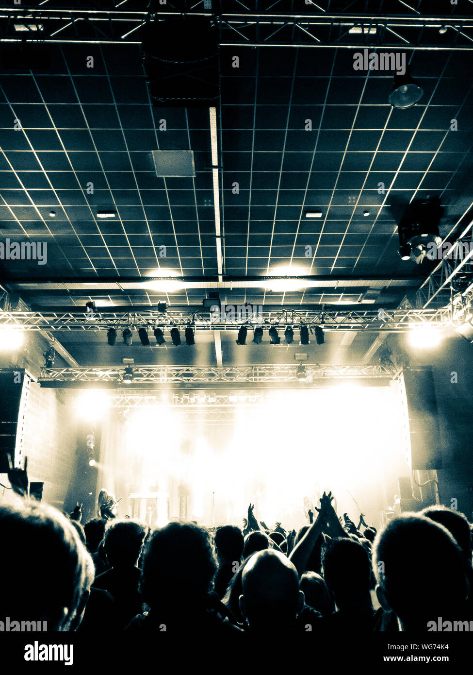 Concert crowd clapping in front of a bright stage Stock Photo - Alamy