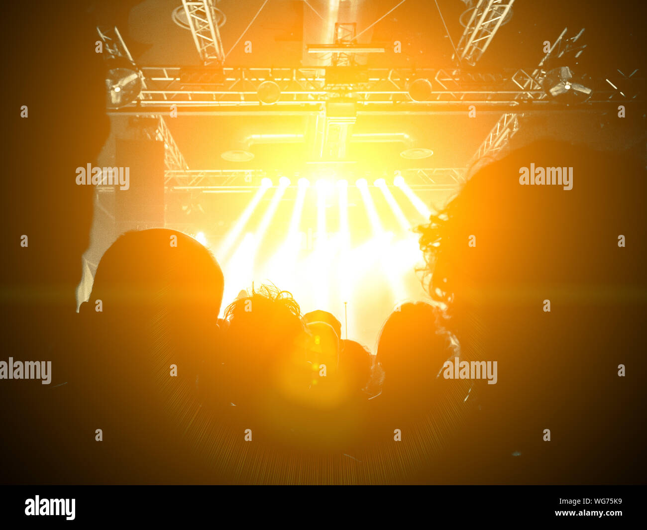 Concert crowd clapping in front of a bright stage Stock Photo - Alamy