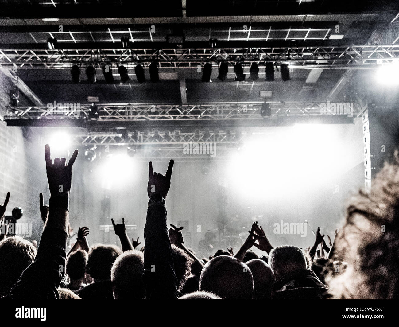 Concert crowd clapping in front of a bright stage Stock Photo - Alamy