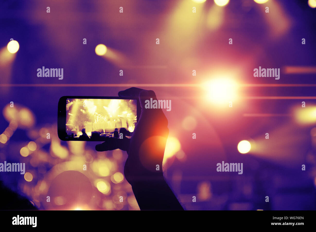 Concert crowd clapping in front of a bright stage Stock Photo - Alamy