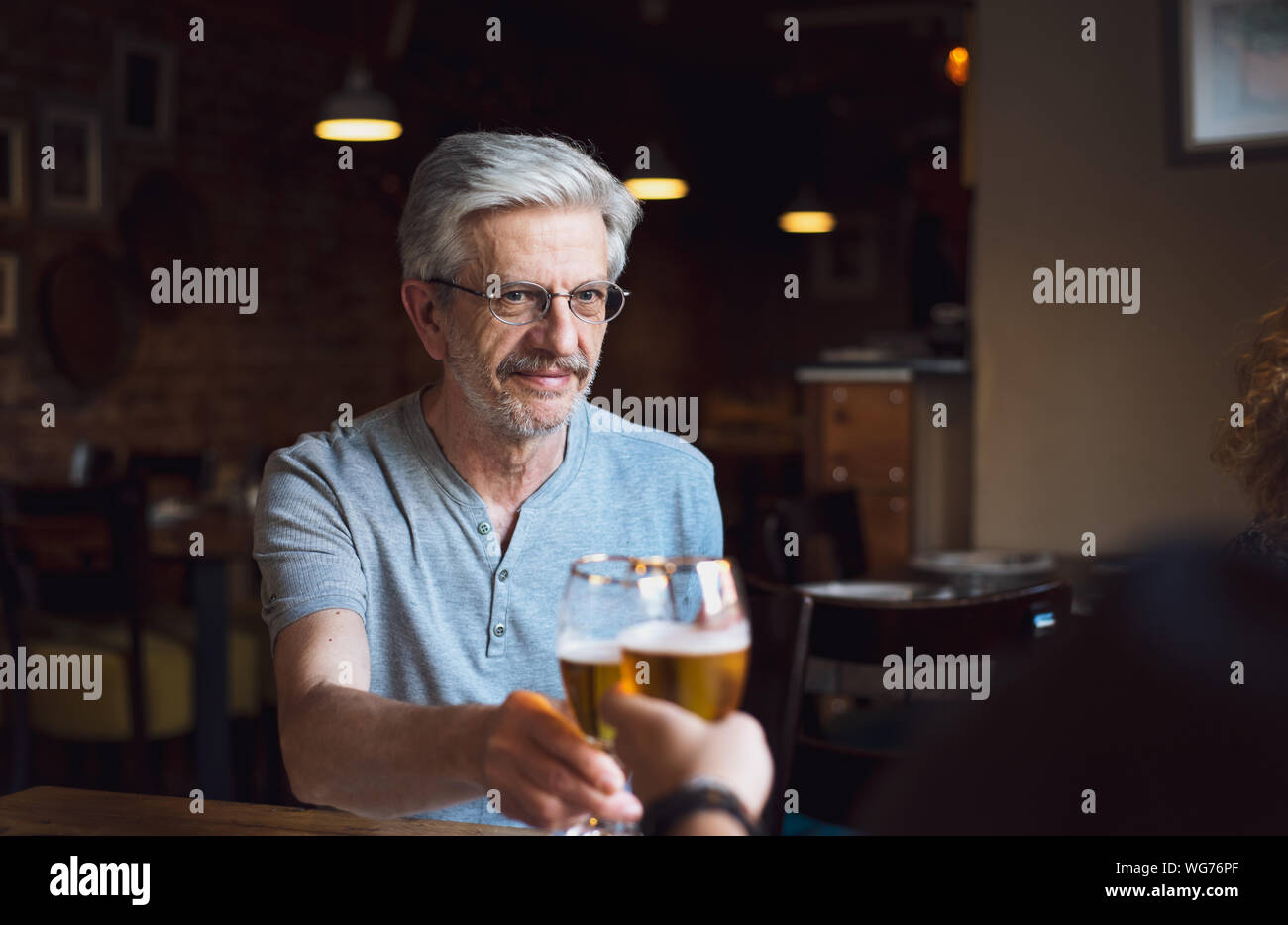 Senior man toasting with a beer in the bar Stock Photo - Alamy