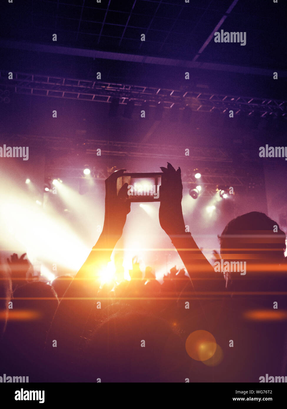 Concert crowd clapping in front of a bright stage Stock Photo - Alamy