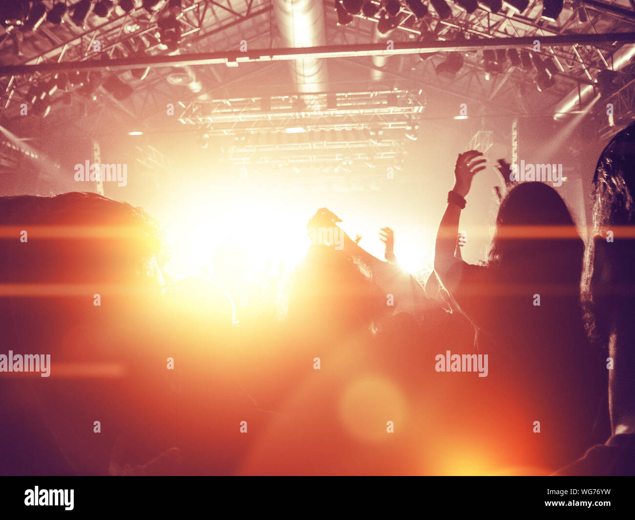 Concert crowd clapping in front of a bright stage Stock Photo - Alamy
