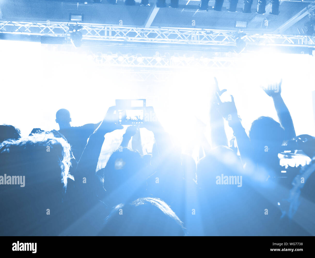 Concert crowd clapping in front of a bright stage Stock Photo - Alamy