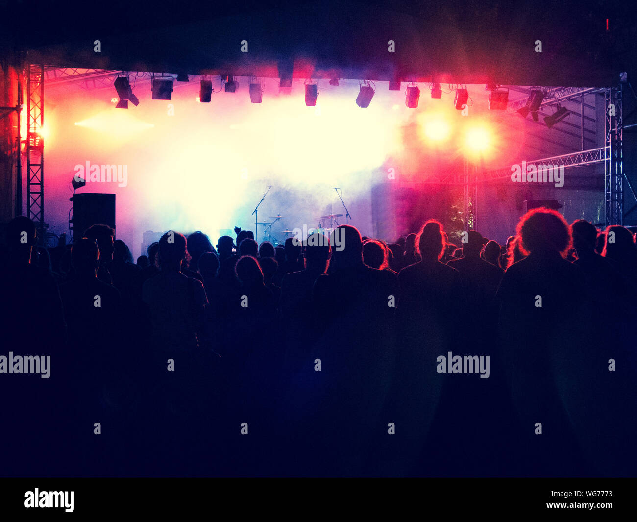 Concert crowd clapping in front of a bright stage Stock Photo - Alamy