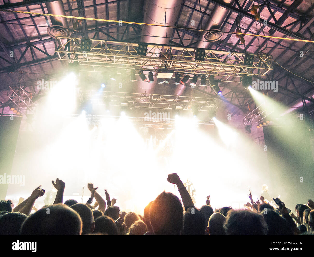 Concert crowd clapping in front of a bright stage Stock Photo - Alamy