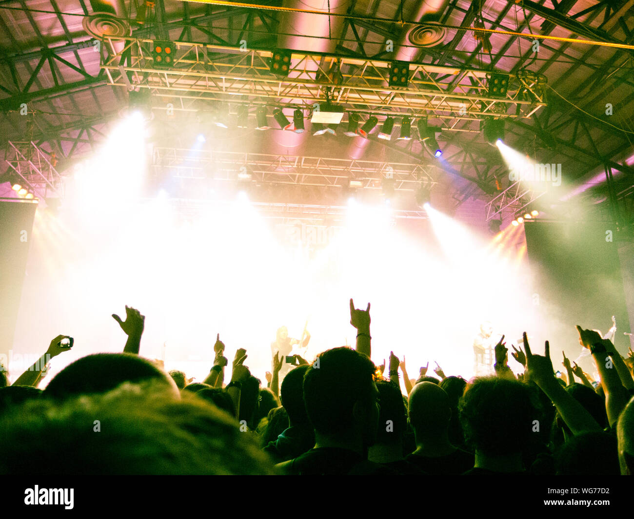 Concert crowd clapping in front of a bright stage Stock Photo - Alamy