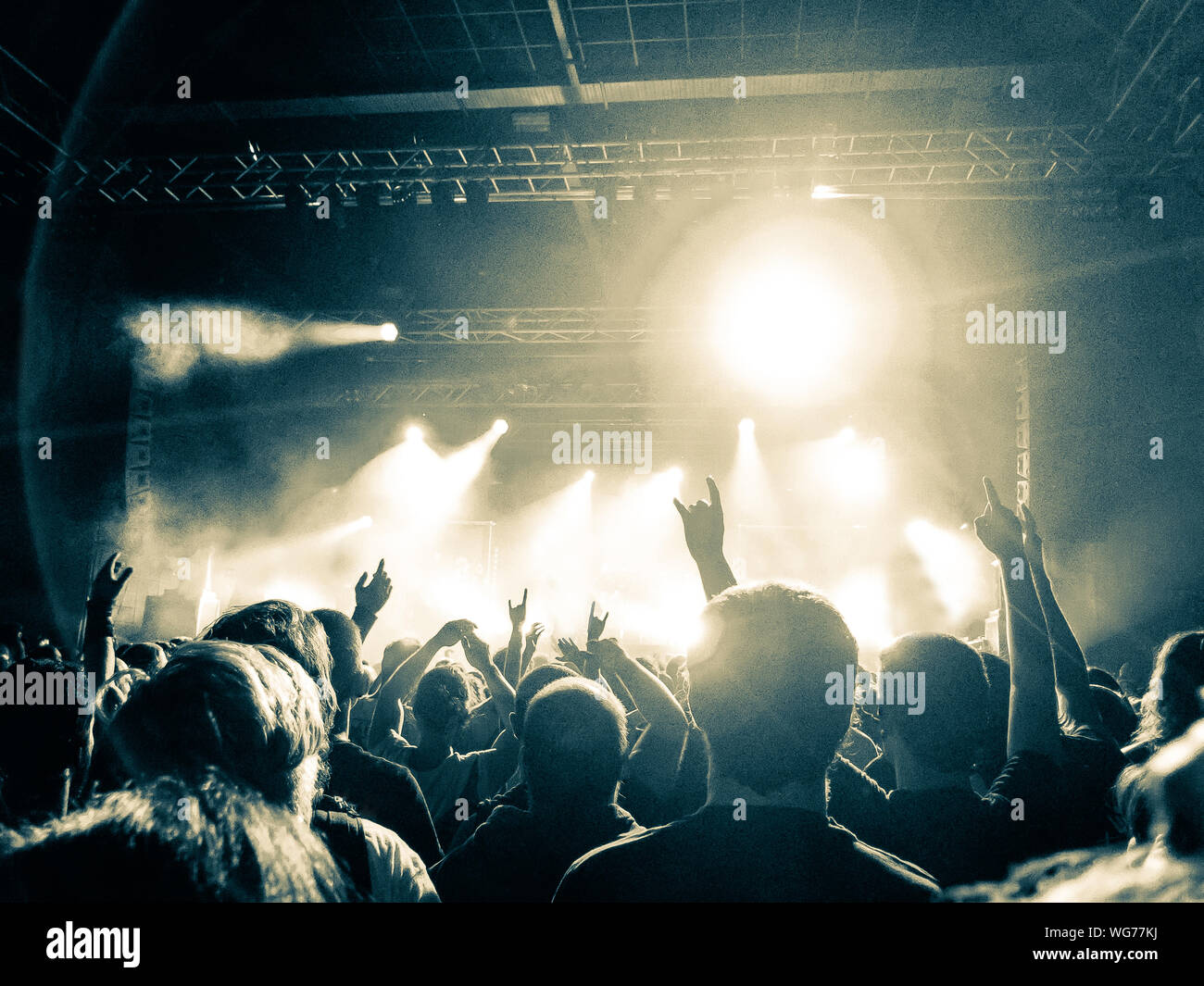 Concert crowd clapping in front of a bright stage Stock Photo - Alamy
