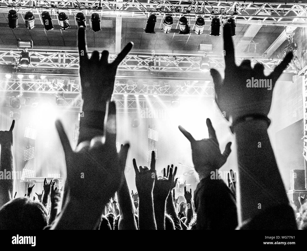 Concert crowd clapping in front of a bright stage Stock Photo - Alamy