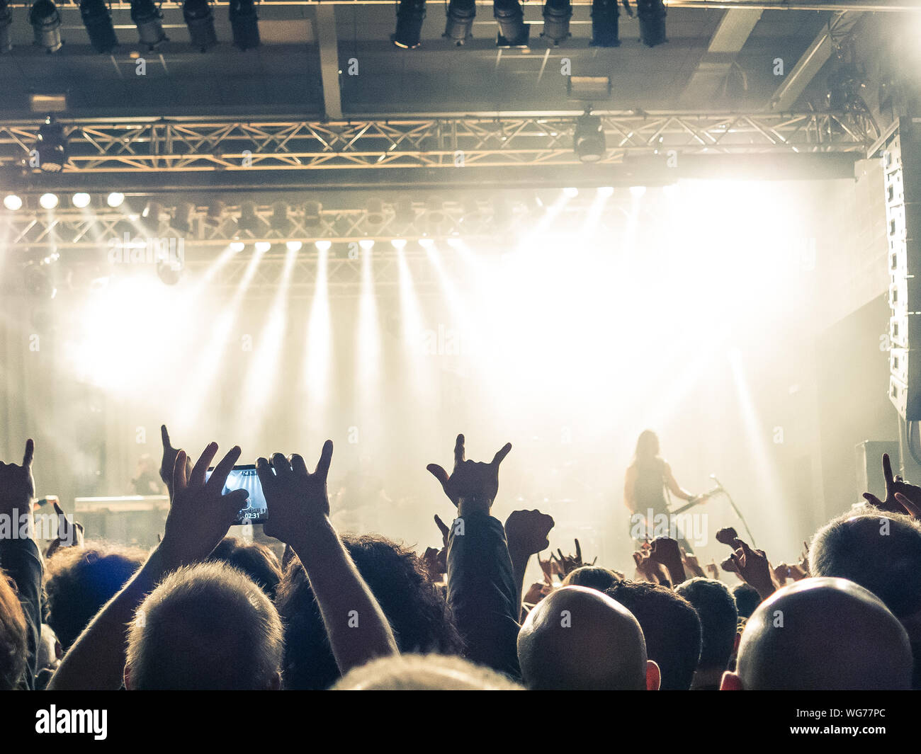 Concert crowd clapping in front of a bright stage Stock Photo - Alamy