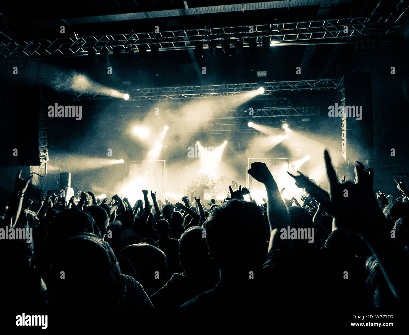 Concert crowd clapping in front of a bright stage Stock Photo - Alamy