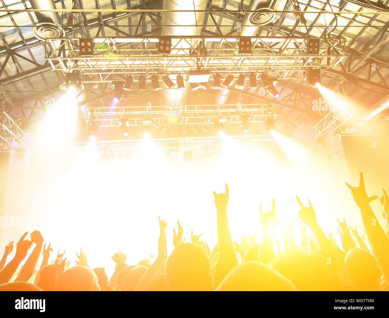 Concert crowd clapping in front of a bright stage Stock Photo - Alamy