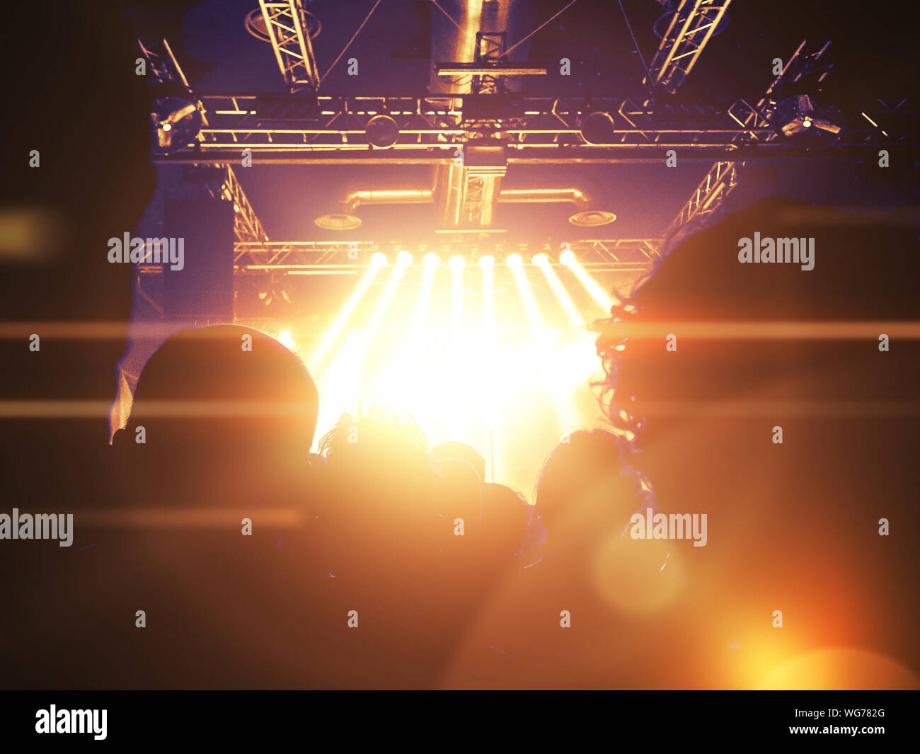 Concert crowd clapping in front of a bright stage Stock Photo - Alamy