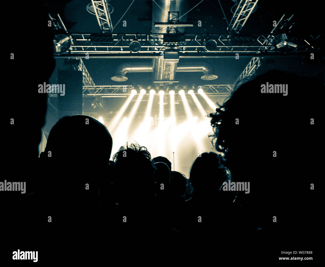 Concert crowd clapping in front of a bright stage Stock Photo - Alamy