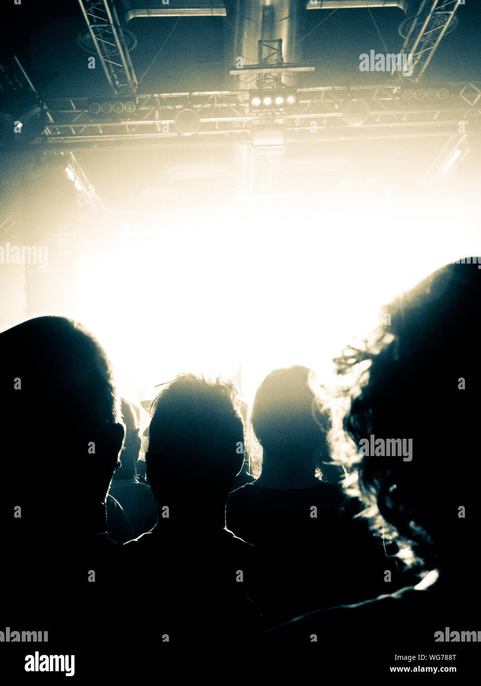Concert crowd clapping in front of a bright stage Stock Photo - Alamy