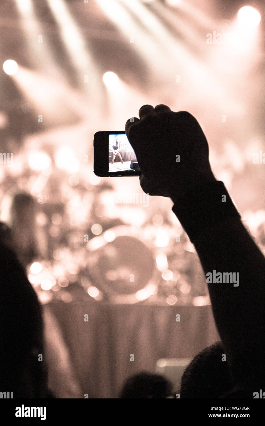 Concert crowd clapping in front of a bright stage Stock Photo - Alamy