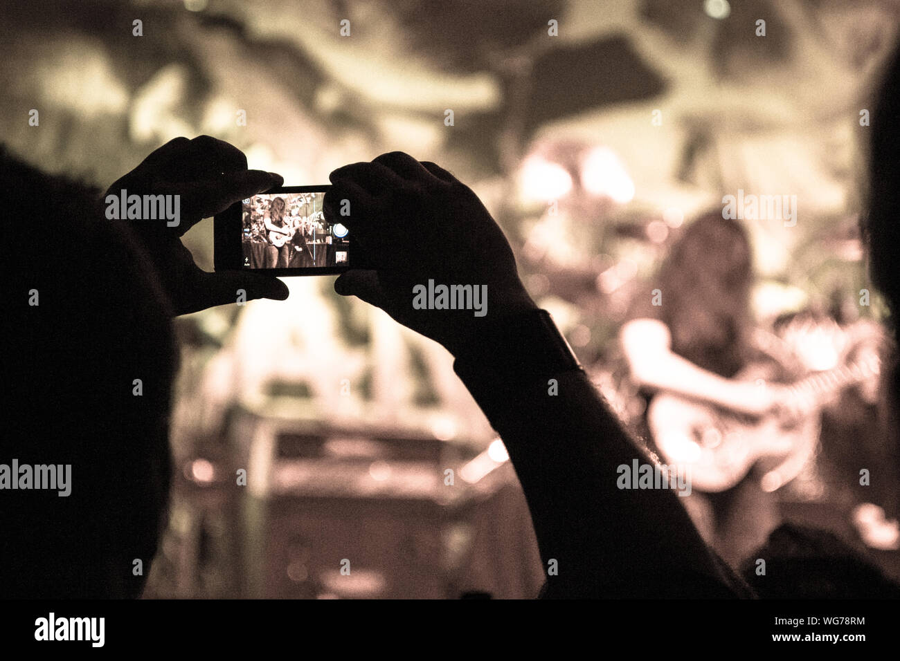 Concert crowd clapping in front of a bright stage Stock Photo - Alamy