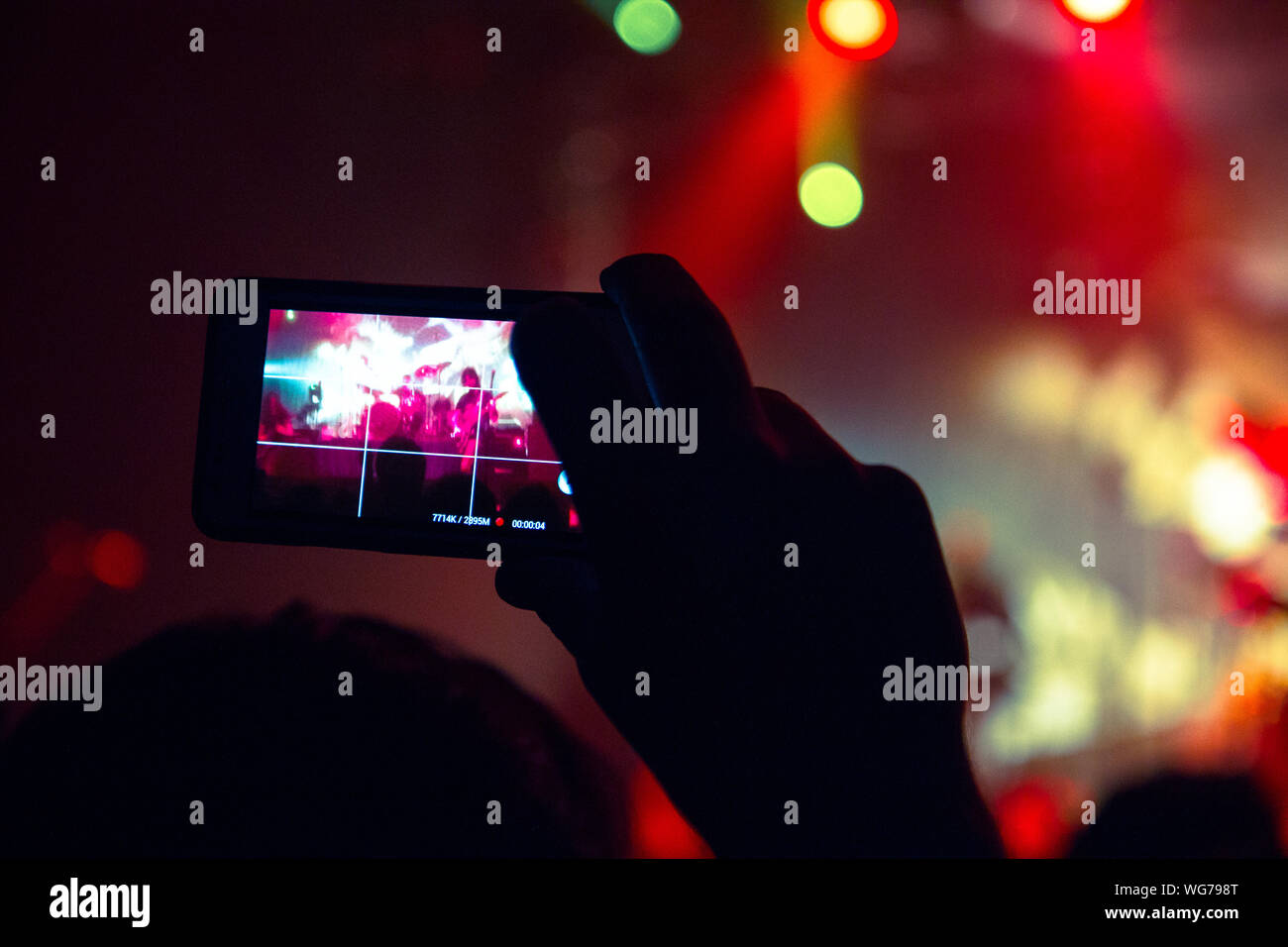 Concert crowd clapping in front of a bright stage Stock Photo - Alamy