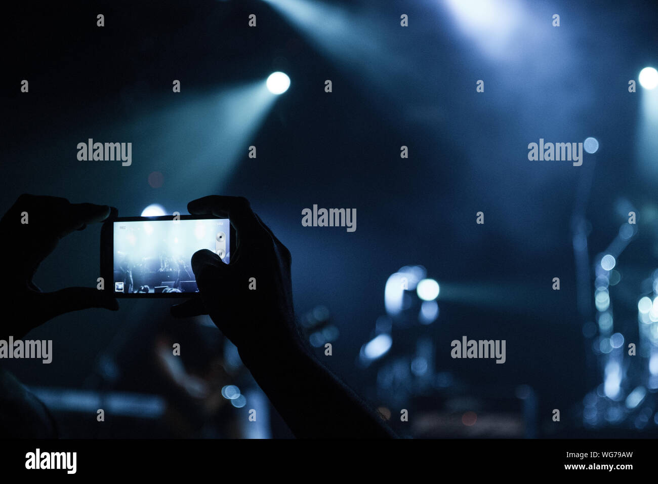 Concert crowd clapping in front of a bright stage Stock Photo - Alamy