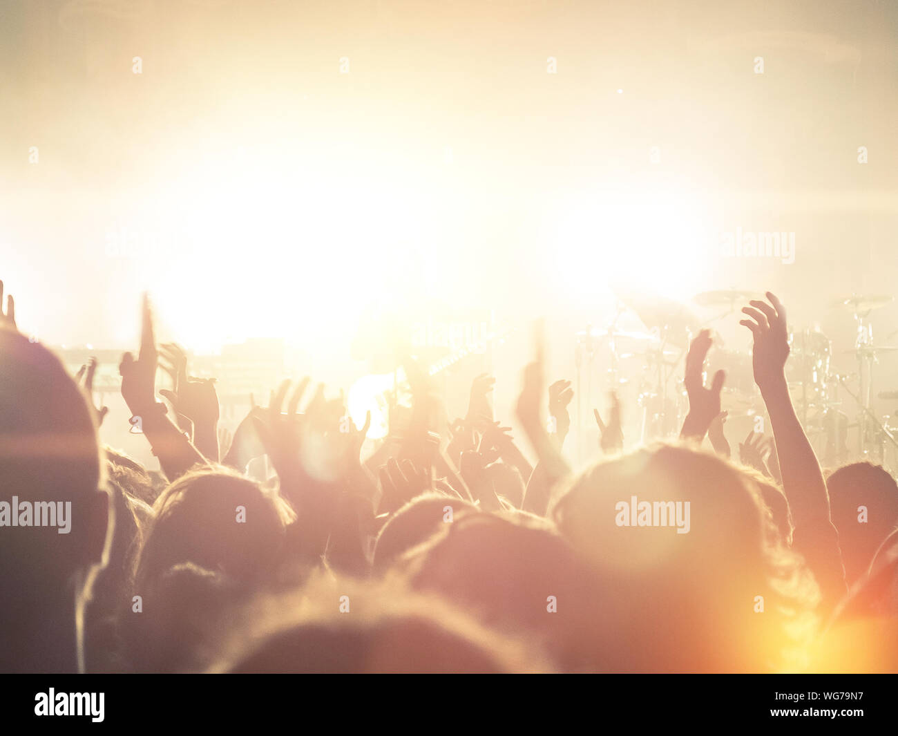 Concert crowd clapping in front of a bright stage Stock Photo - Alamy