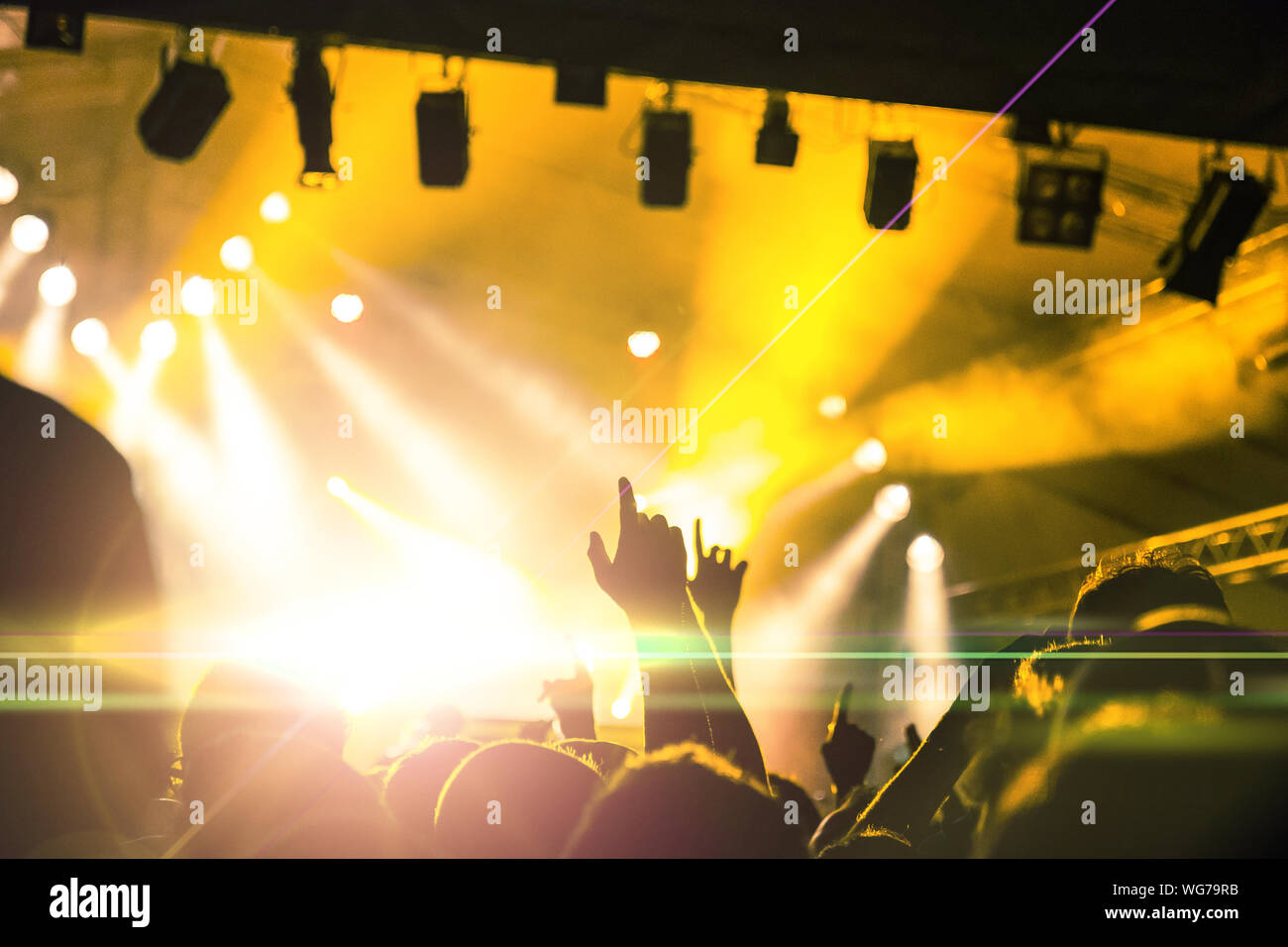 Concert crowd clapping in front of a bright stage Stock Photo - Alamy