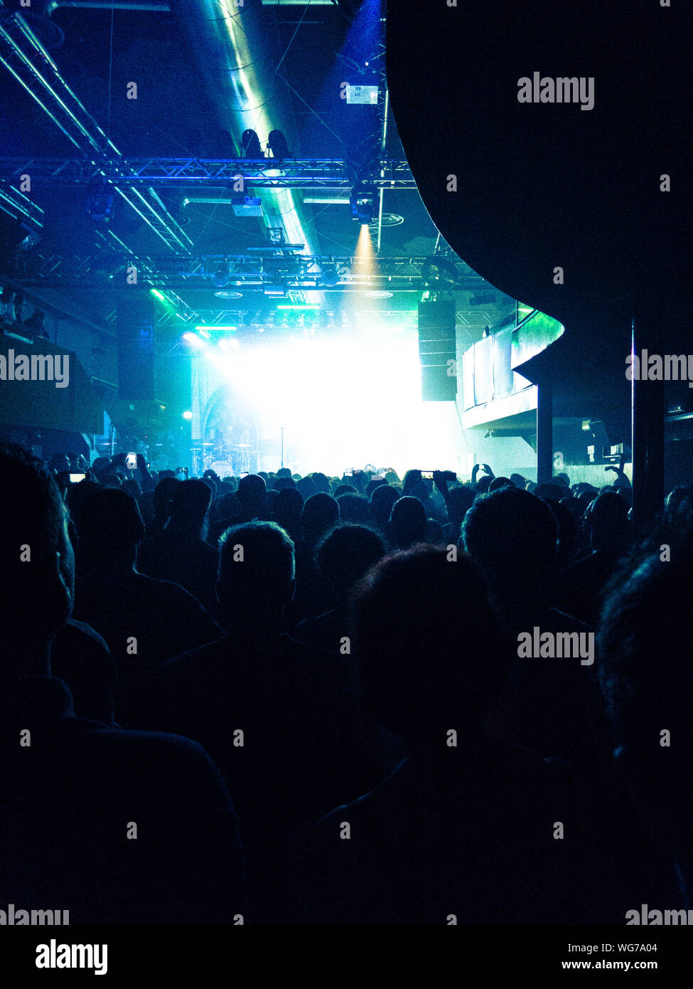 Concert crowd clapping in front of a bright stage Stock Photo - Alamy